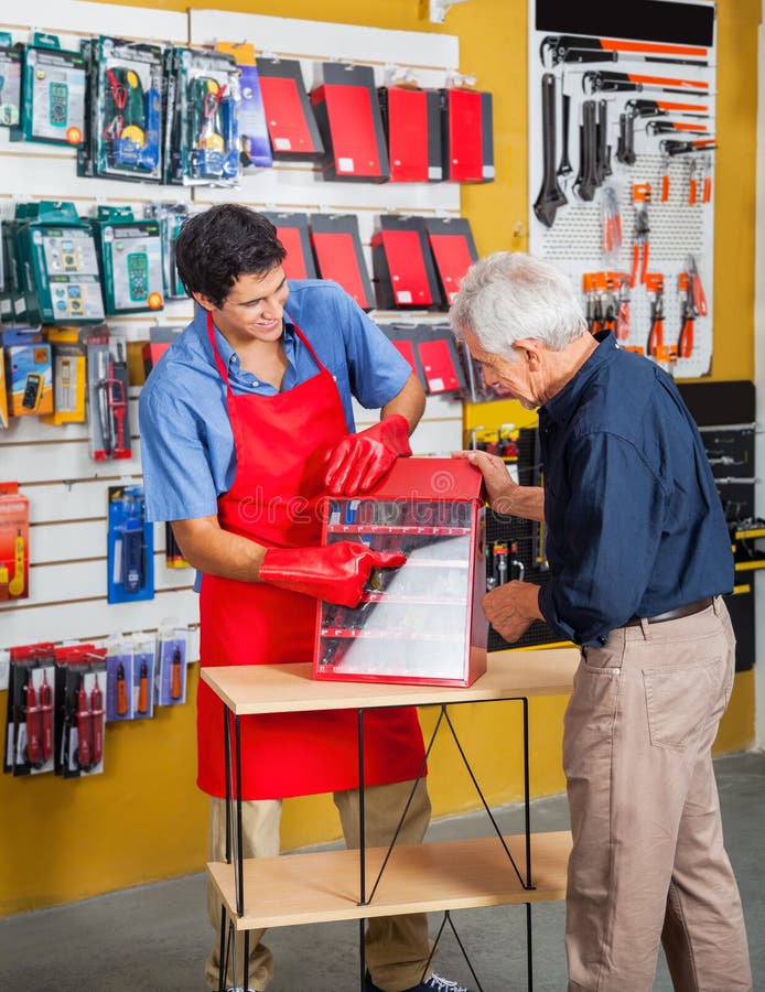 Salesman Guiding Man in Selecting Tools at Store Stock Photo - Image of ...