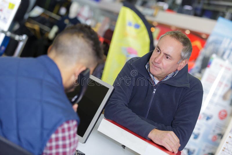 Salesman Serving Customer in Boutique Stock Photo - Image of talk ...