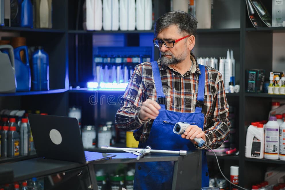 Salesman Using Barcode Scanner and Laptop in Auto Parts Store Stock ...