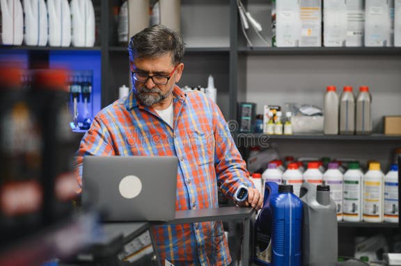 Salesman Using Laptop and Holding Barcode Scanner in Auto Parts Store ...