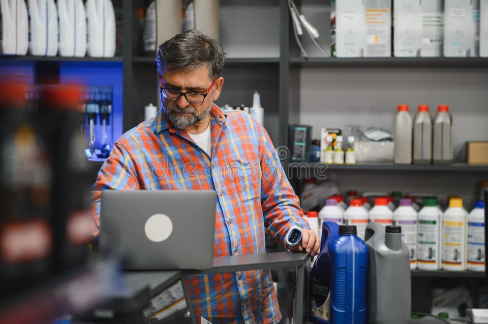 Salesman Using Laptop and Holding Barcode Scanner in Auto Parts Store ...