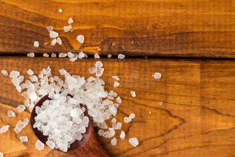 Salt in a Wooden Spoon on a Wooden Table. Large Pieces of Salt in a ...