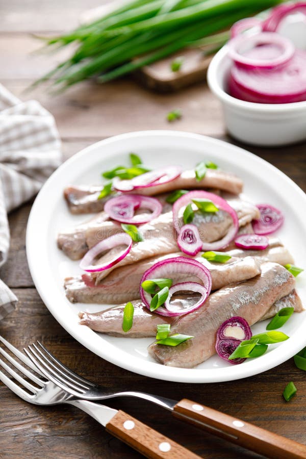 Salted, Marinated Herring Fillet with Onion on Plate Stock Photo ...