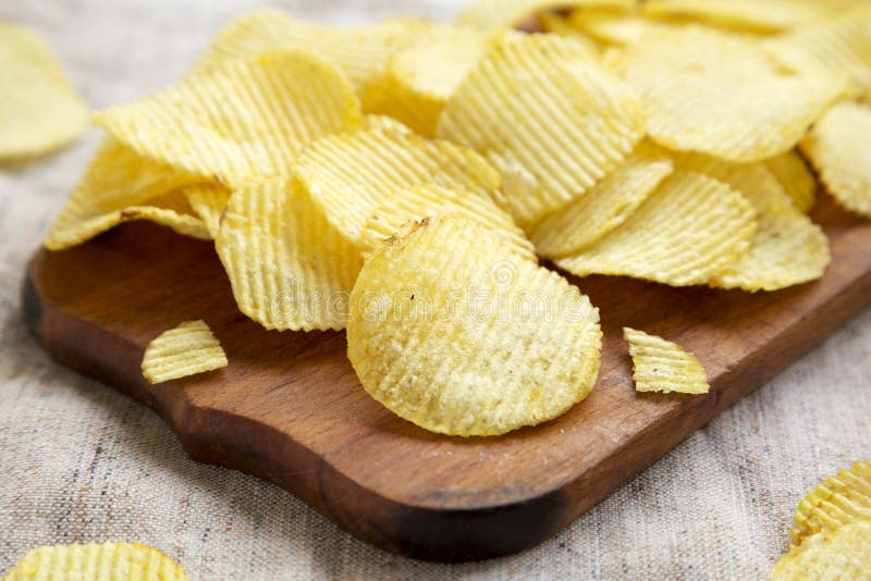 Salted Wavy Potato Chips on a Rustic Wooden Board, Side View. Close-up ...