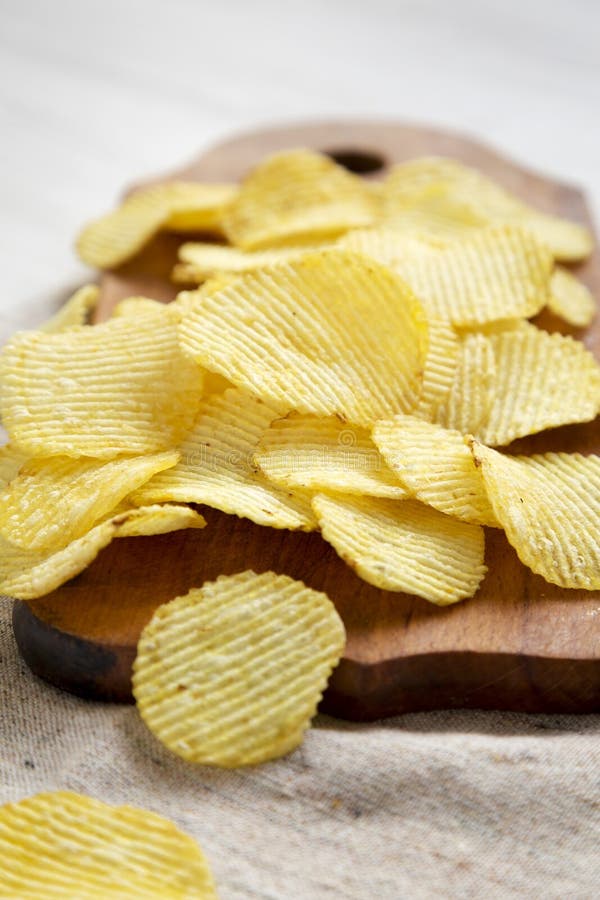 Salted Wavy Potato Chips on a Rustic Wooden Board, Side View. Close-up ...
