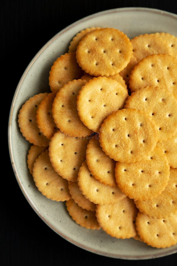Salty Round Crackers on a Plate on a Black Surface, Top View. Flat Lay ...