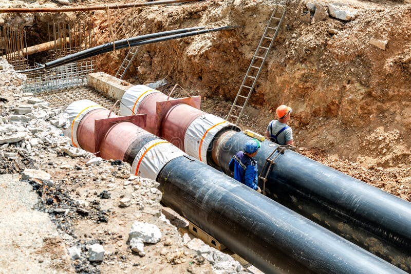 Workers in Protective Helmets at the Construction Works on a Pipeline ...
