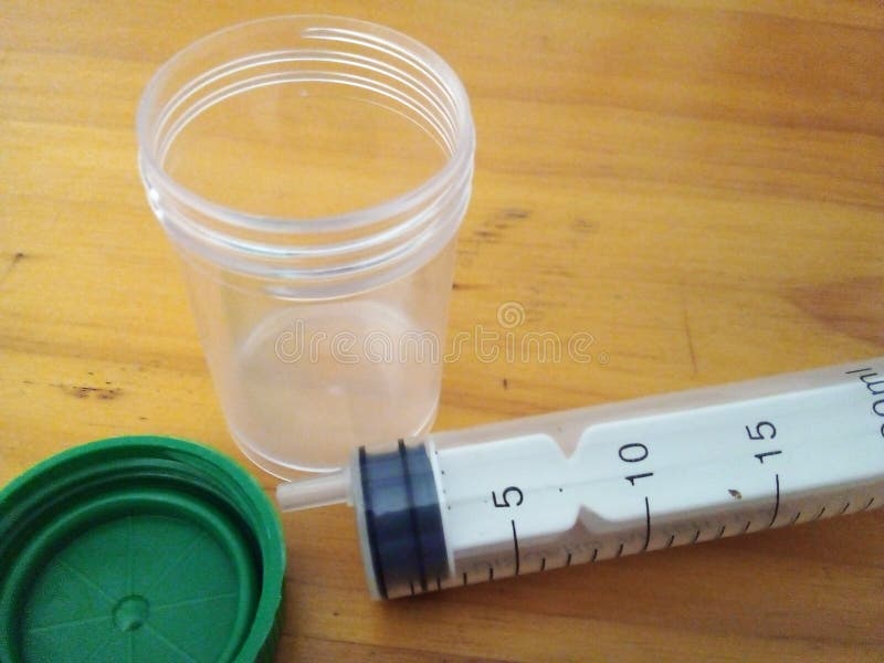 A Sample Cup and Syringe stock image. Image of liquid - 253659793