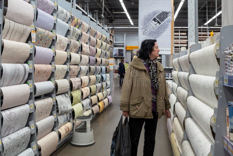 Samples of Different Wallpapers on Store Window Racks. Woman Choose ...