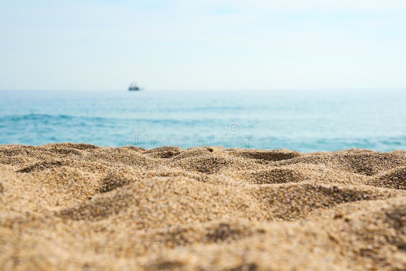 Sand on the Beach Close Up with Blurred Sea, Ship and Waves on a ...