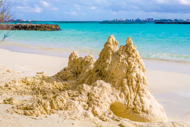 Sand Castle on the Beach in Front of Ocean with Male in the Back Stock ...