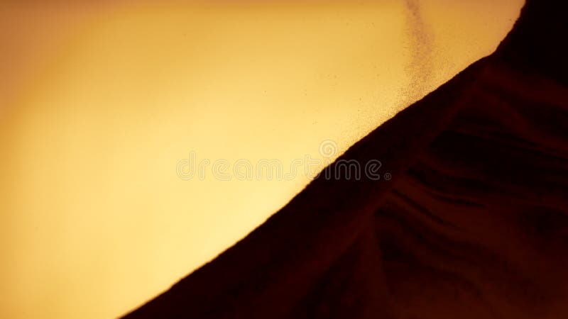Sand Falling Down on the Hill Under the Yellow Light in Abstract Slow ...