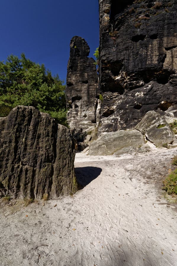Sand Path Leading To a Bunch of Rock Formations and Tall Cliffs Stock ...