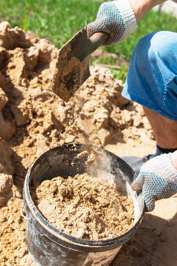 Sand shoveling in a bucket stock image. Image of planting - 205748231