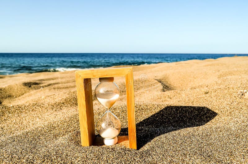 A Sand Timer is Sitting on the Beach, with the Sand Around it Stock ...
