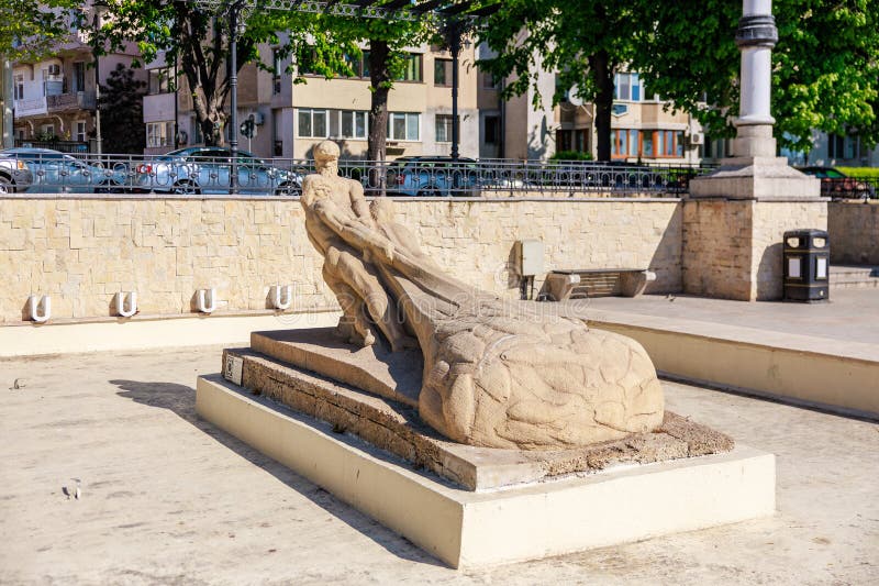 Sandstone Sculpture of Man Pulling Rock in Urban Park Setting. May 3 ...