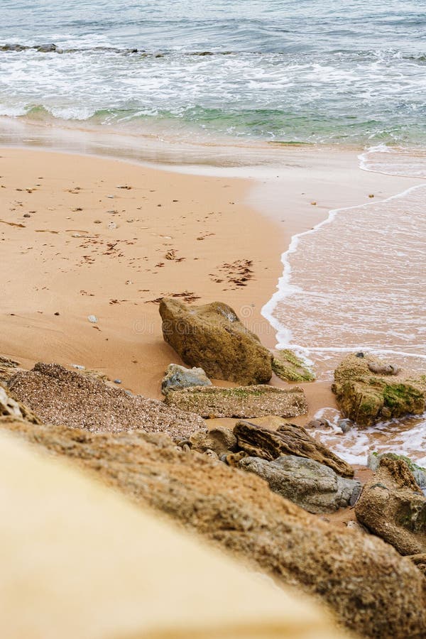 Sandy Beach with Rocks Against the Backdrop of Tranquil Waves. Stock ...