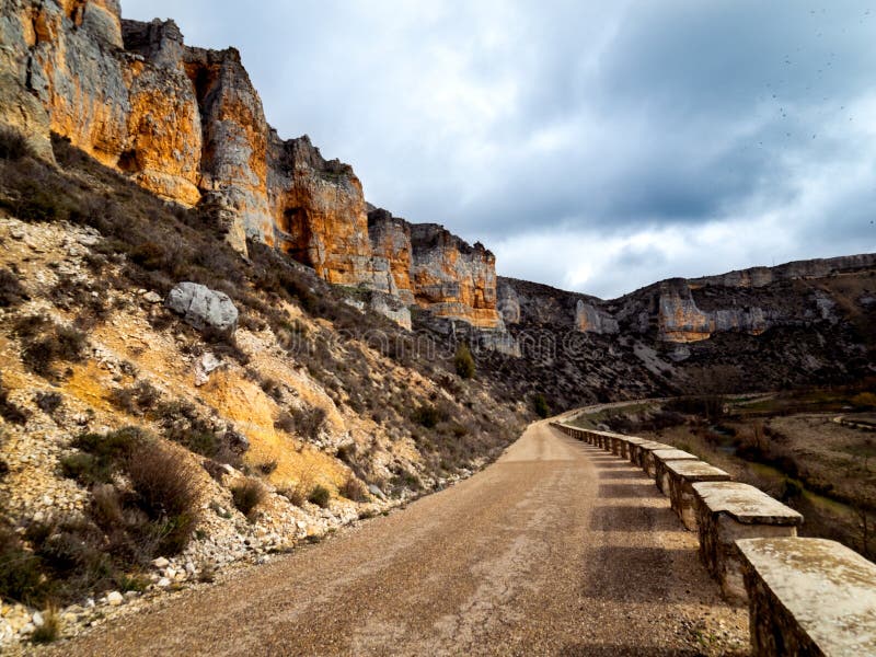 Sandy Path Surrounded by Rocky Mountains and a Small Stone Wall Stock ...