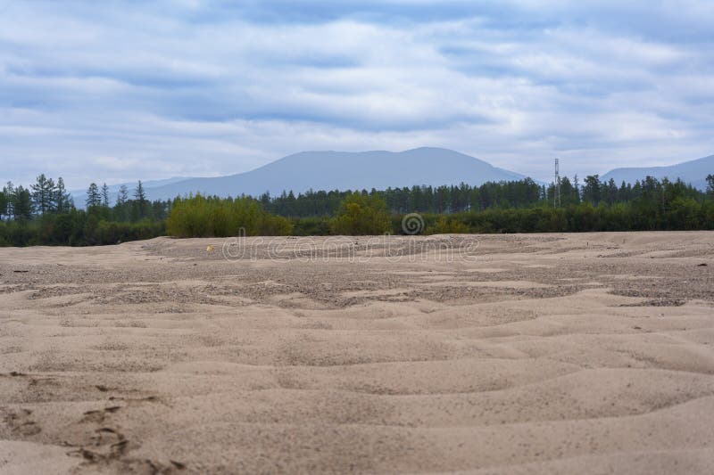 Sandy Terrain with Forest and Mountains Under Cloudy Sky Stock Photo ...