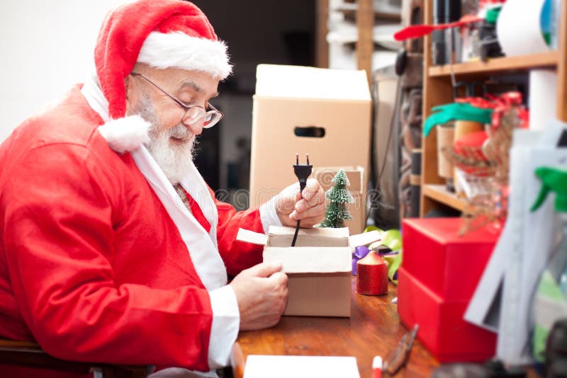 Santa Claus packing a gift stock photo. Image of christmastime - 104944310