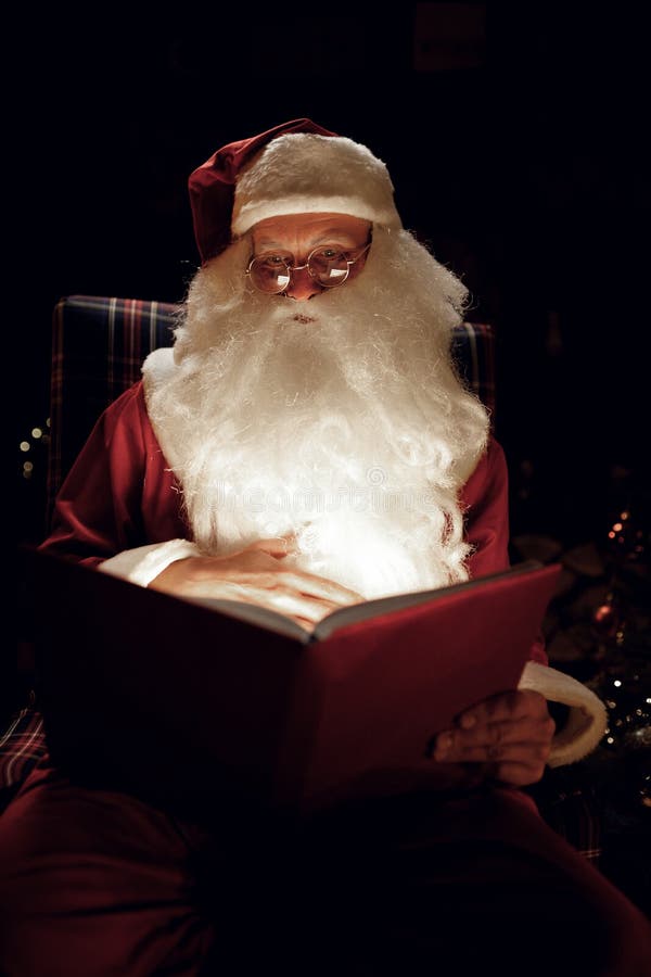 Santa Claus Reading a Magic Book while Sitting in a Dark Room Stock ...