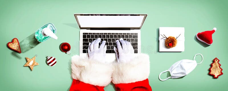 Santa Claus Using a Laptop Computer with a Mask and a Sanitizer Bottle ...