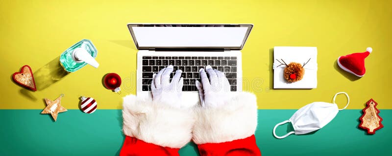 Santa Claus Using a Laptop Computer with a Mask and a Sanitizer Bottle ...