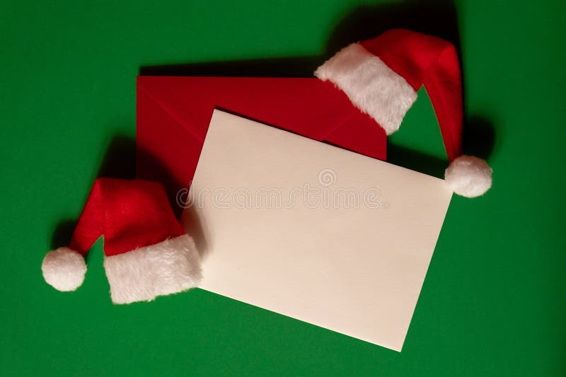 Santa Hat with Empty Paper Card Note Envelope on Green Background. Copy ...