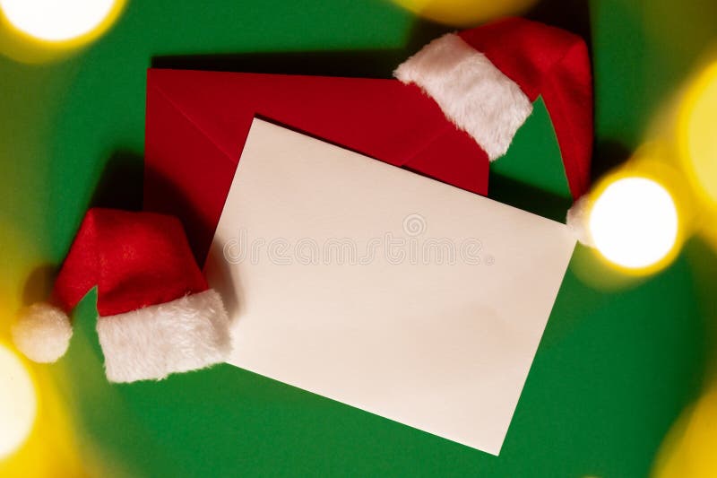 Santa Hat with Empty Paper Card Note Envelope on Green Background. Copy ...