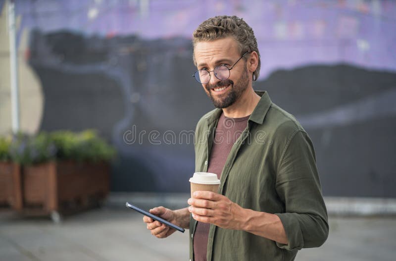 Sarcastic Man Typing a Message on His Phone while Enjoying a Cup of ...