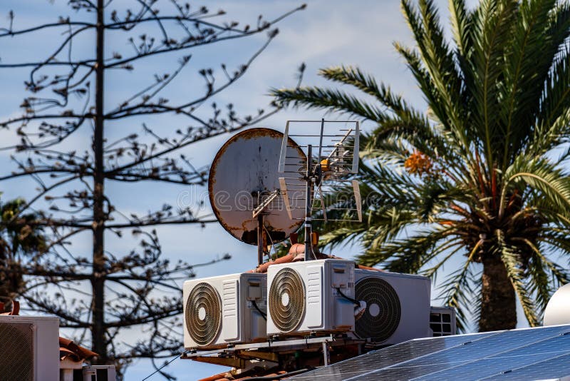 A Satellite Dish is Mounted on a Rooftop with Two Air Conditioners ...