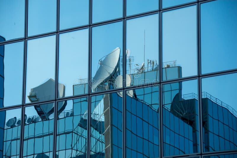 Satellite Dishes Reflected in the Windows of a Modern Office Building ...