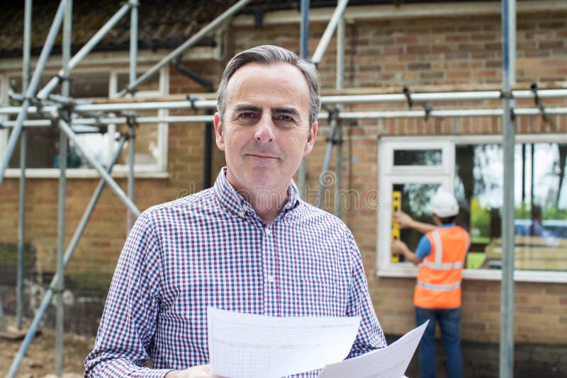 Satisfied Client Looking at Bills for House Building Work Stock Image ...