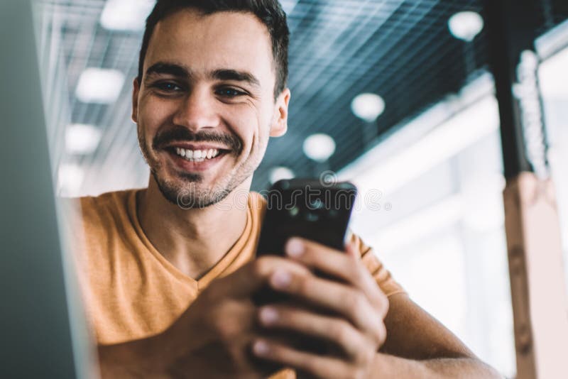 Satisfied Remote Worker Messaging on Phone Watching Laptop at Workplace ...