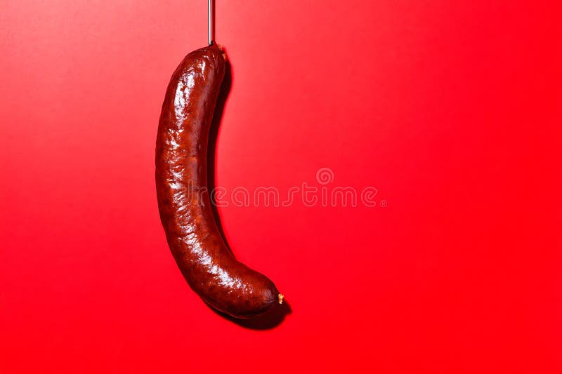 Single Sausage Hanging Against a Red Background Stock Image - Image of ...