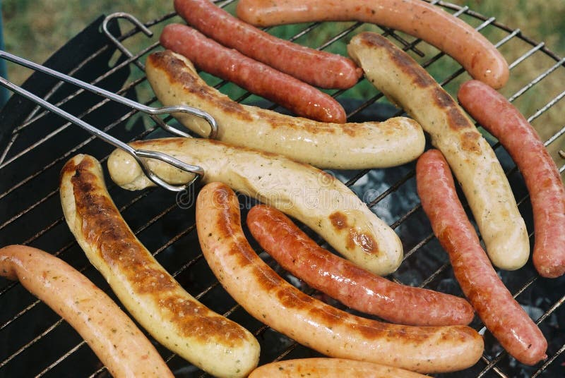 Sausages on Barbecue grill stock photo. Image of hands - 5940432