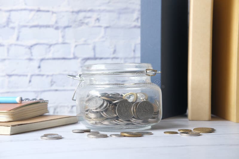 Saving Jar and Coins and Stack of Books on Table Stock Image - Image of ...
