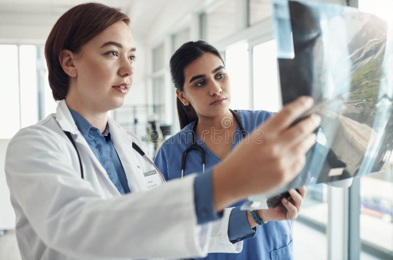 Saving One Life at a Time. Two Young Doctors Checking Exrays in a ...