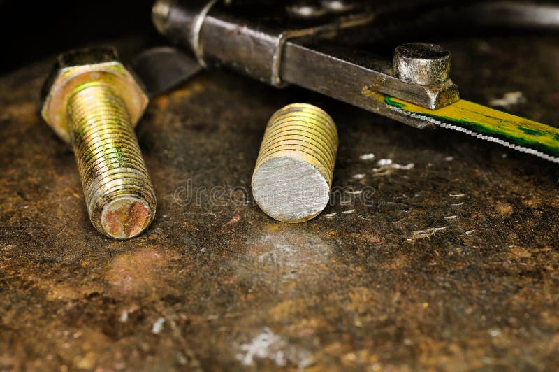 Sawed-off Bolt and Metal Saw Lying on a Rusty Metal Stock Image - Image ...