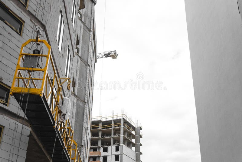 Scaffold Elevator Hanging On Building Under Construction With Gray Sky ...