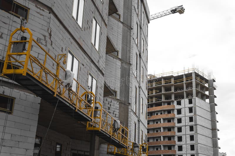 Scaffold Elevator Hanging on Building Under Construction with Gray Sky ...
