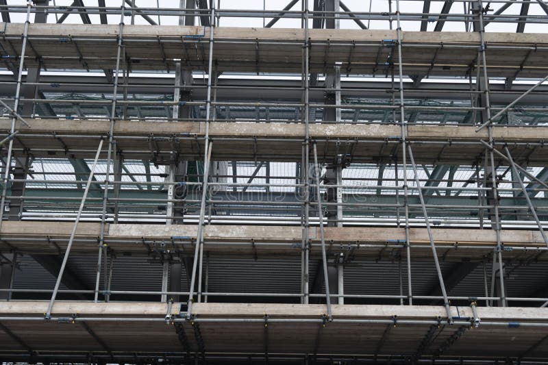 Scaffolding Bars and Planks Rise Infront of a Steel Frame Building ...