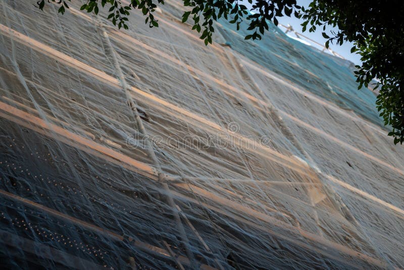 Scaffolding Mesh and Tree Leaves- Construction Site Background Stock ...