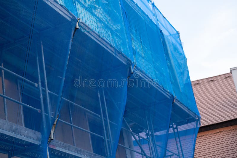 Scaffolding in a Protective Blue Grid. Building Work. Home Construction ...