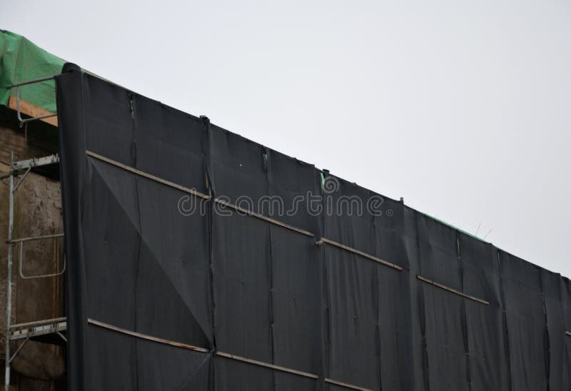 Scaffolding of a Repaired House on the Street. is Covered with a Green ...
