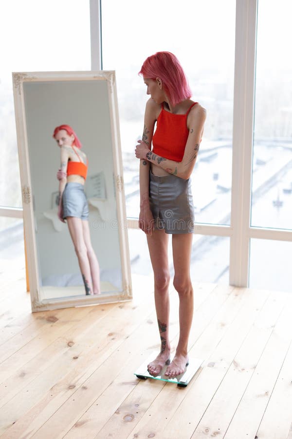 Skinny Anorexic Woman With Long Legs Sitting Near The Window Stock