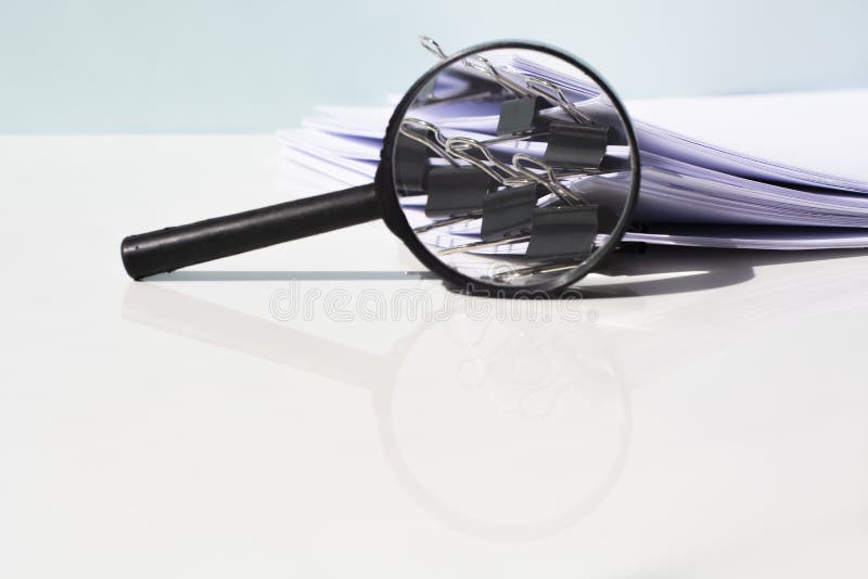 Scanning Business Documents. Magnifying Glass on the Stack of Documents ...