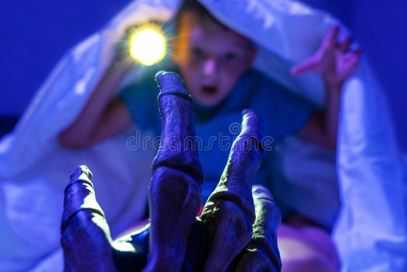 Scared Boy with a Flashlight Hides Under the Blanket from the Hand of a ...