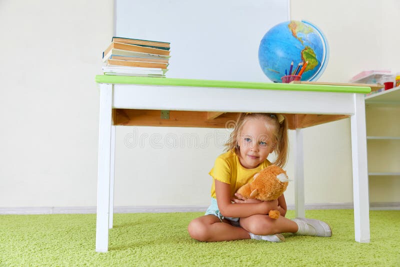 Scared Girl Hiding Under Table Sitting on a Floor Stock Photo - Image ...