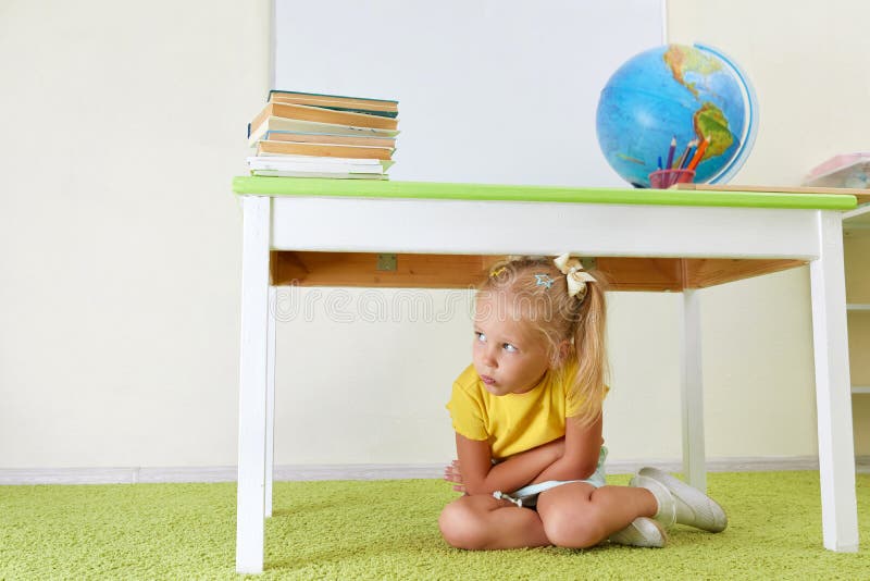 Scared Girl Hiding Under Table Sitting on a Floor Stock Photo - Image ...